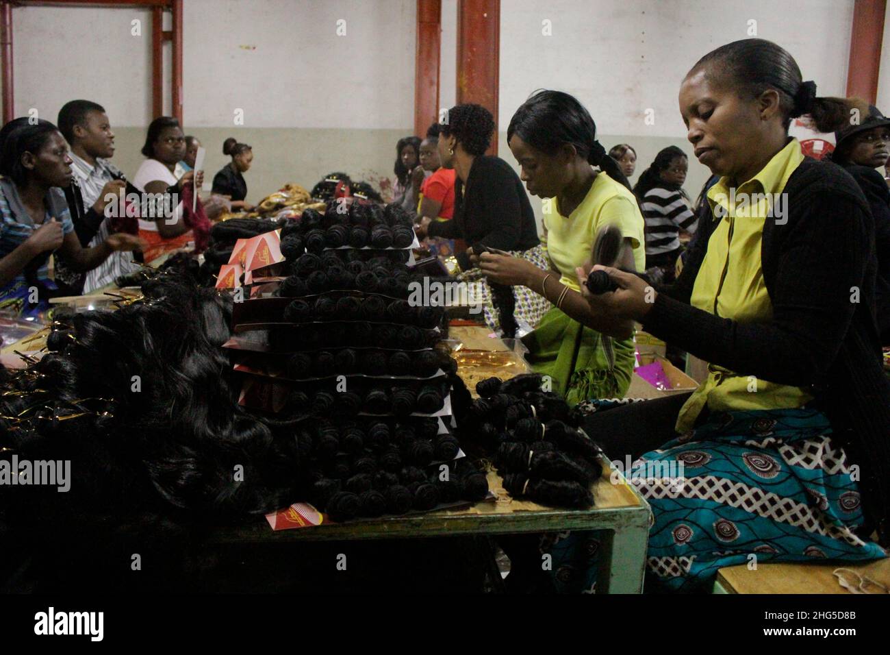 Women are seen packing away weaves in a weave-making factory in Harare ...