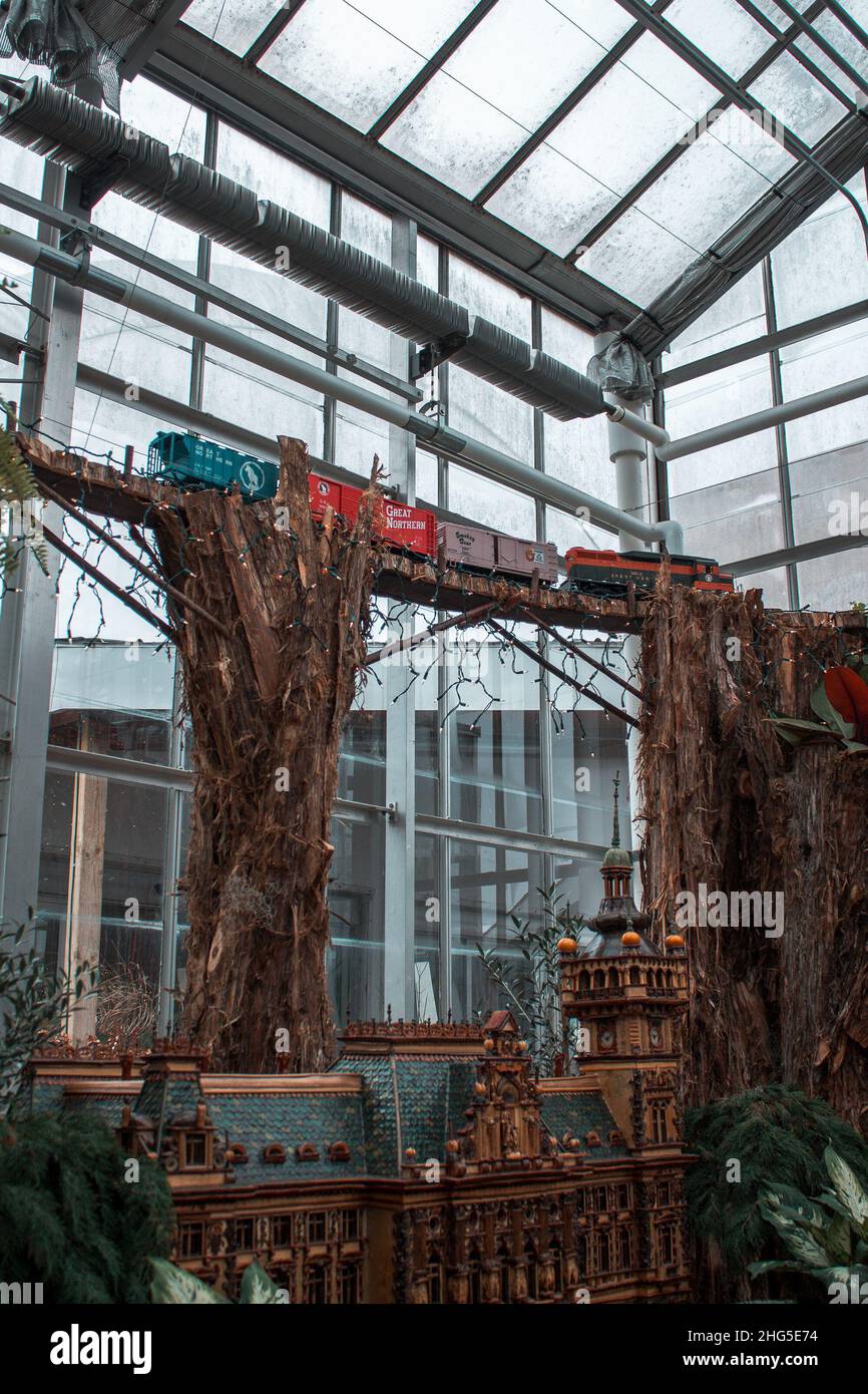 Model train driving across a bridge made of nature elements in a ...