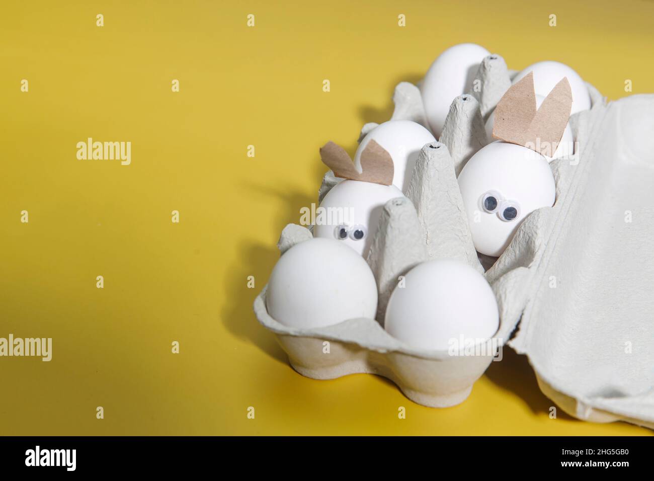 A cheerful white eggs with glasses in a box with ordinary eggs ...