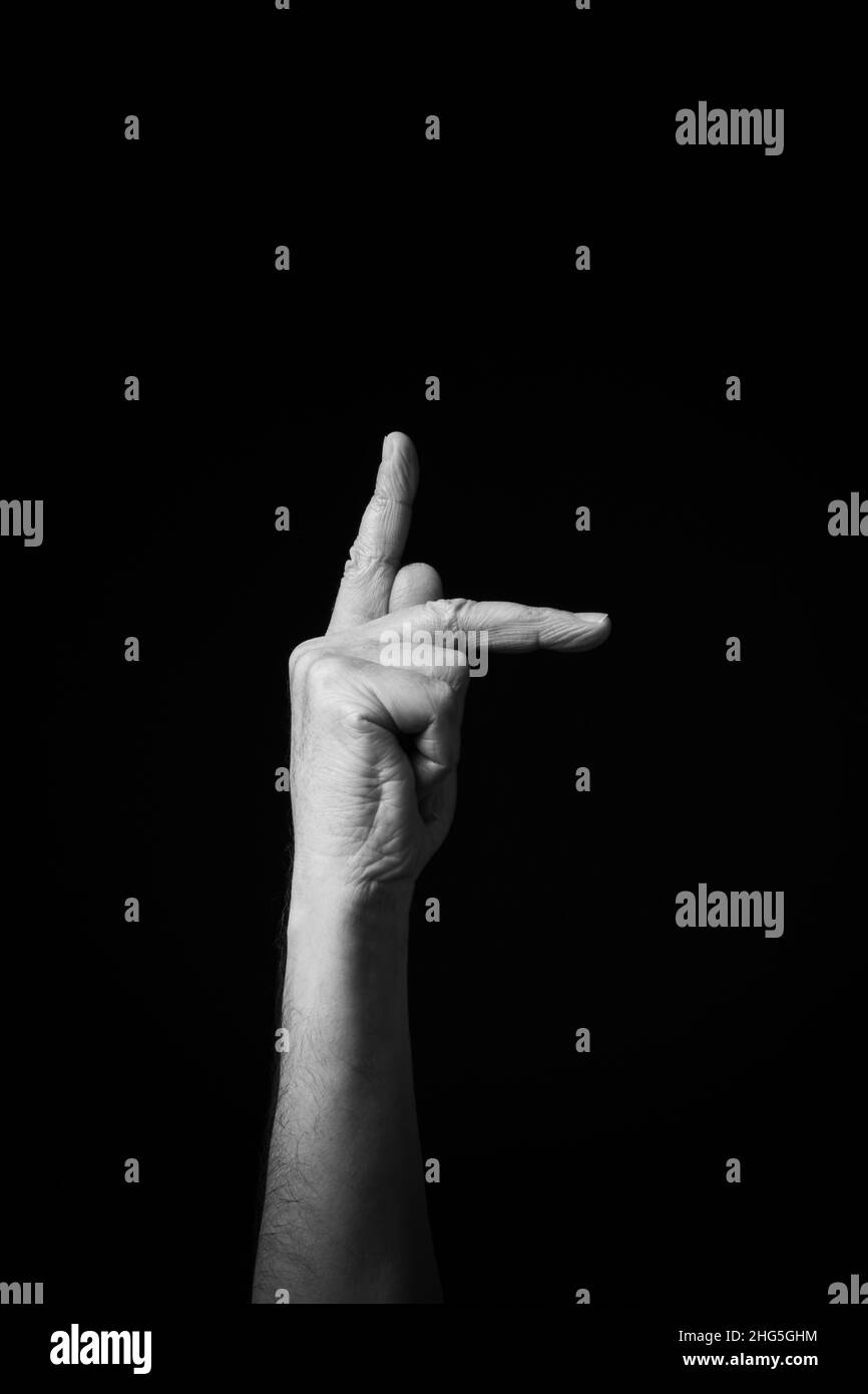 Dramatic B+W image of male hand fingerspelling CSL Chinese sign ...