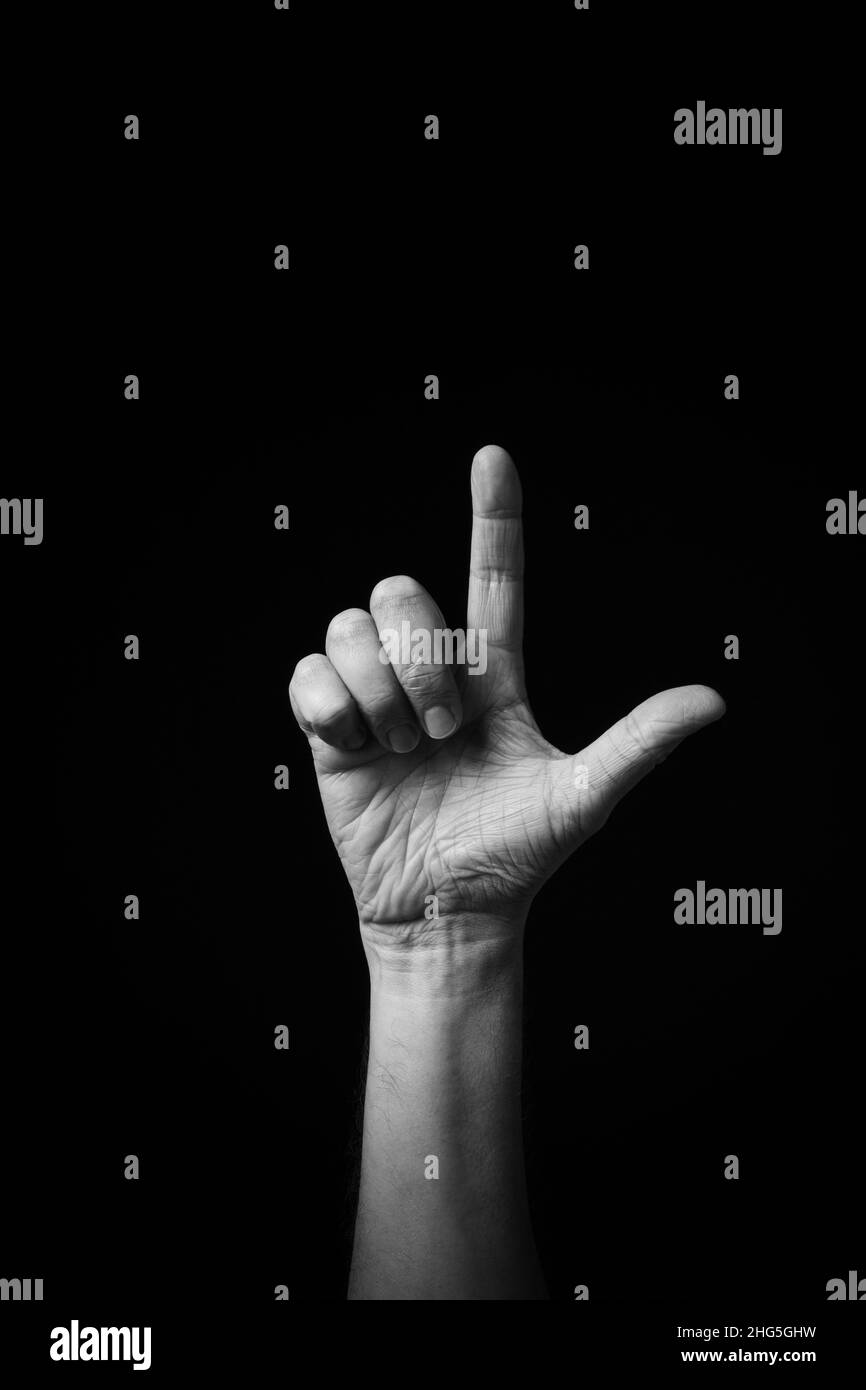 Dramatic B+W image of male hand fingerspelling CSL Chinese sign ...