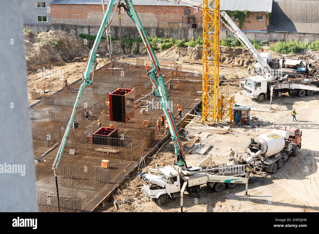 concreting work: construction site worker during concrete pouring into ...