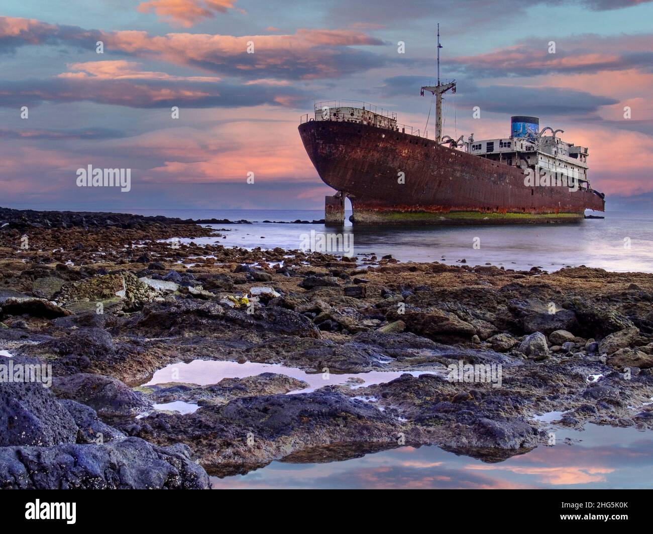 Rusting shipwreck lies in shallow water cove hi-res stock photography ...