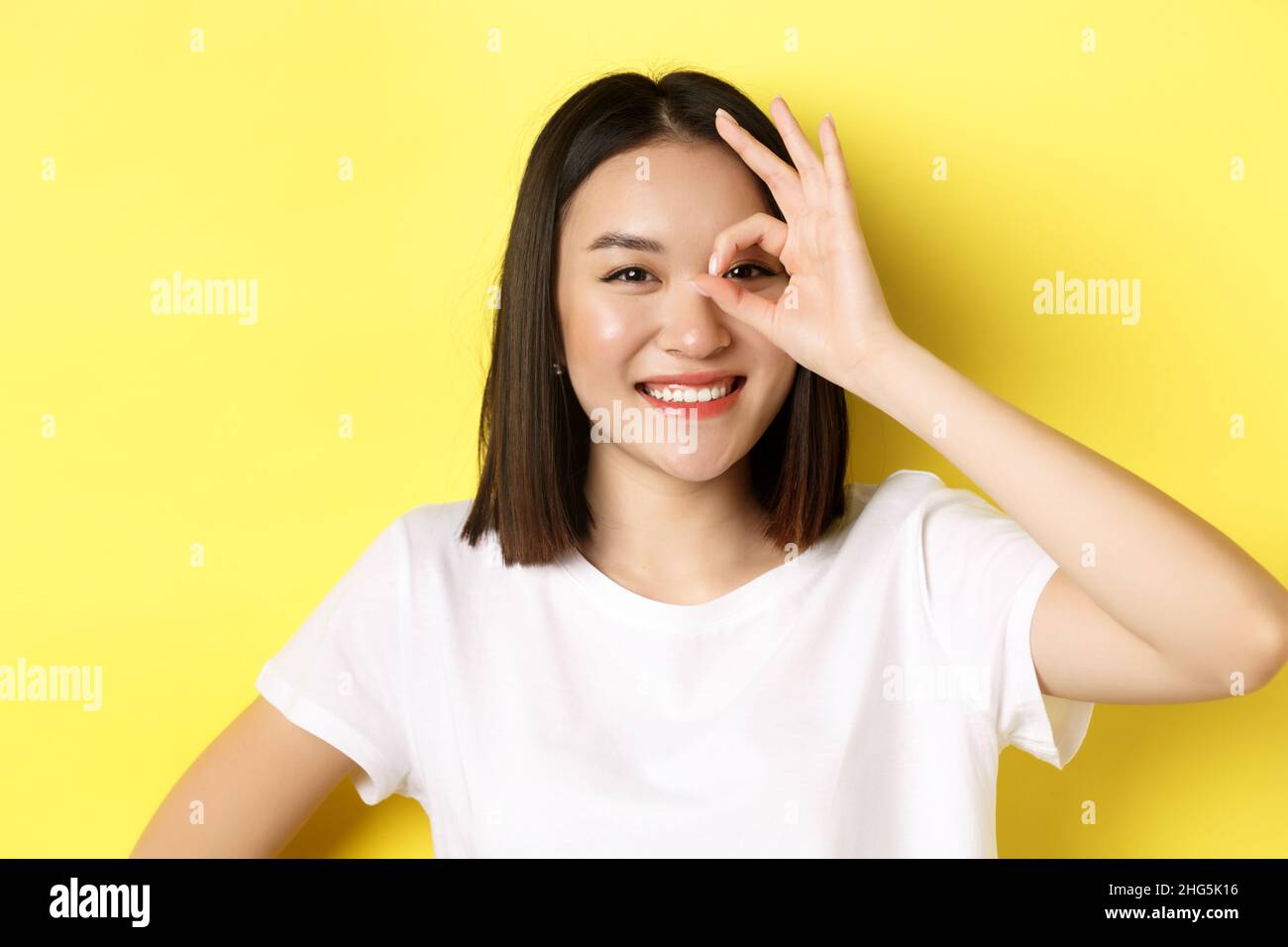 Close up of cute asian girl feeling happy, showing OK sign on eye and ...