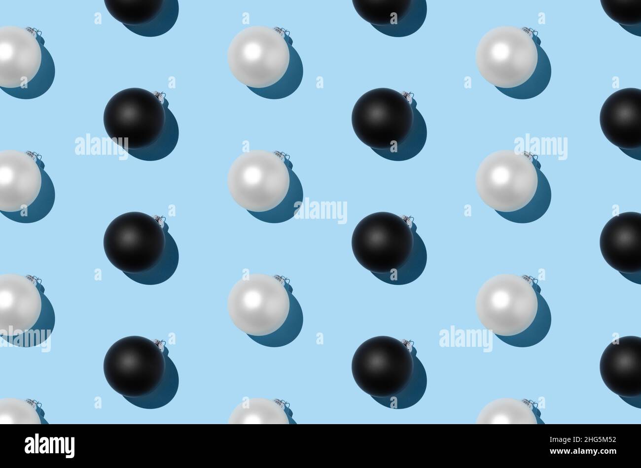 White and black Christmas balls pattern on a pastel blue background ...