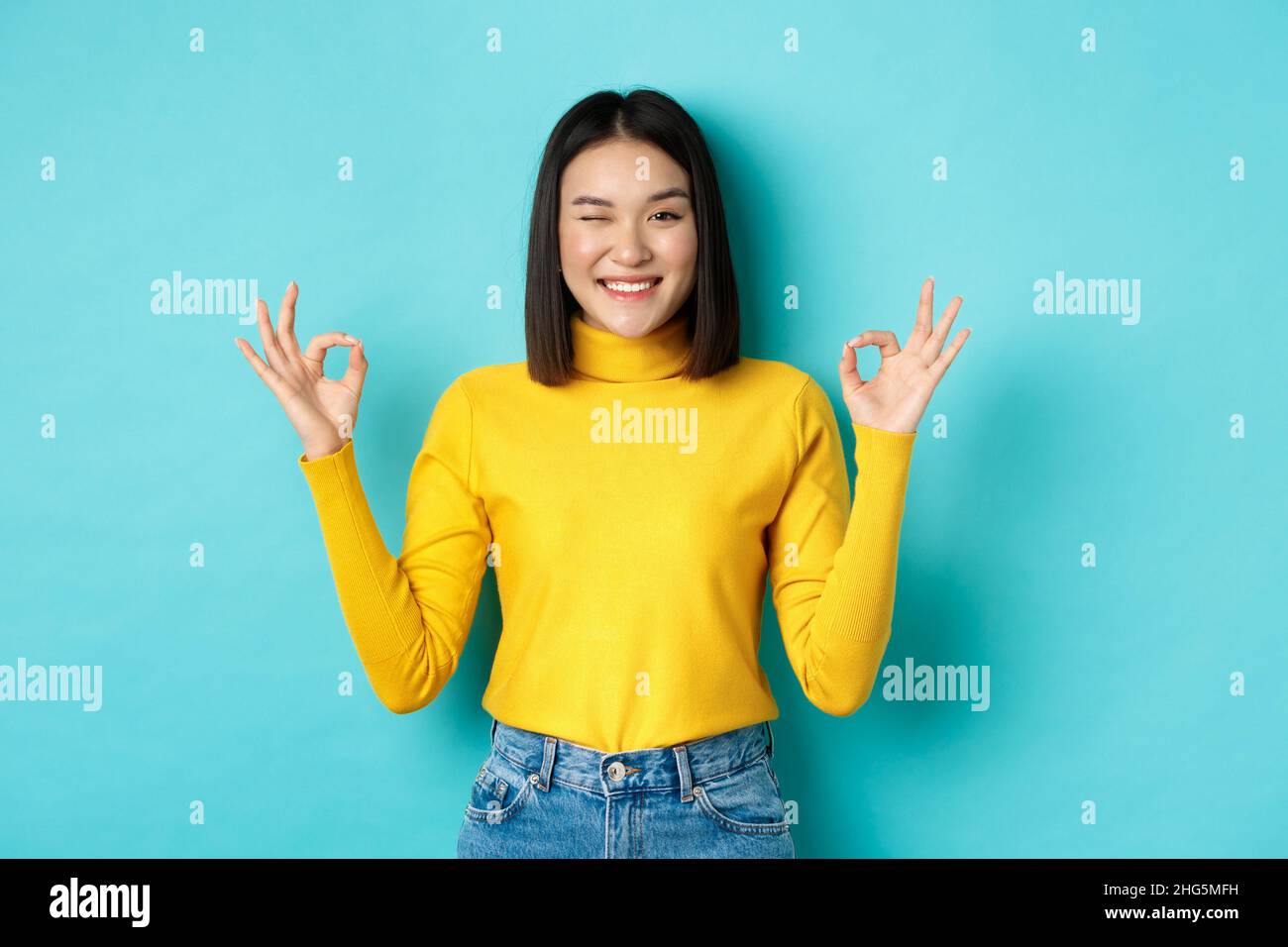 Cheerful asian female model showing okay gestures, smiling and looking ...