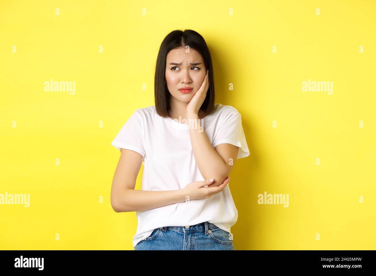 Sad asian woman touching cheek and frowning, having toothache, need see ...