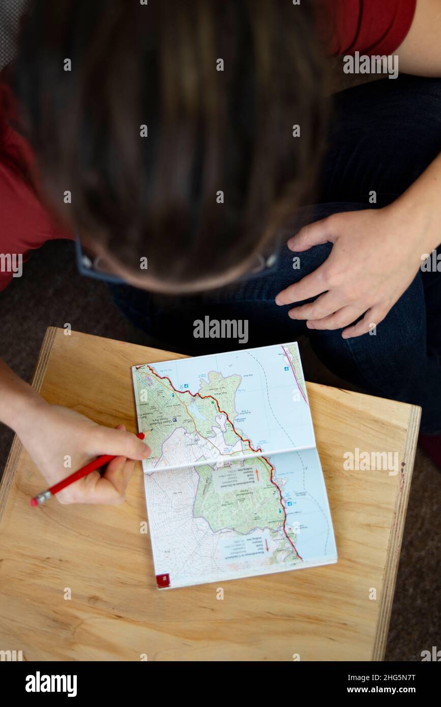 Person planning a trip with a map and a guidebook Stock Photo - Alamy