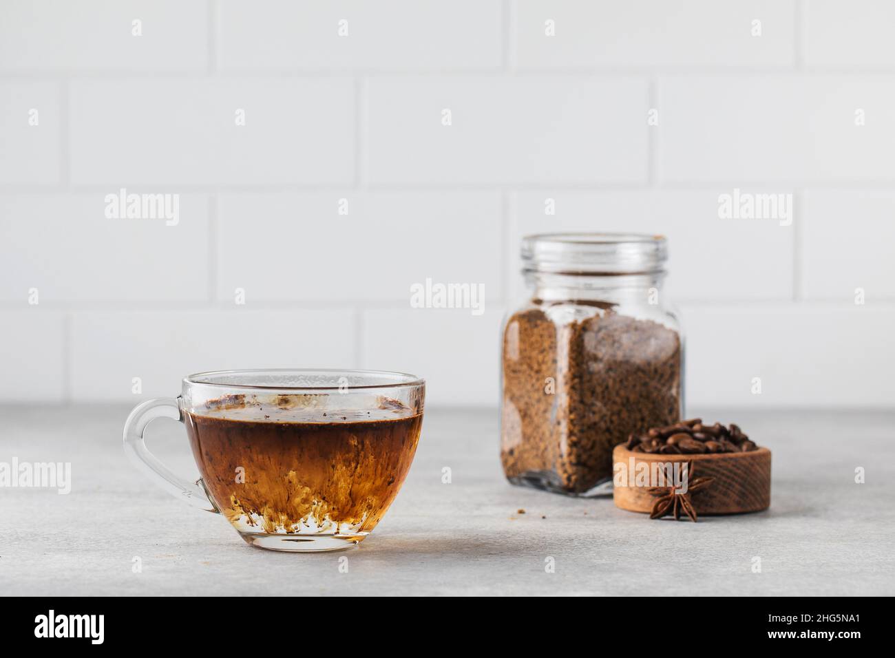 Freeze-dried coffee dissolves in a mug of hot water on grey stone table ...