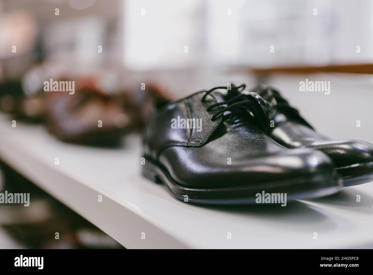 Black leather men's boots in a shoe store Stock Photo - Alamy