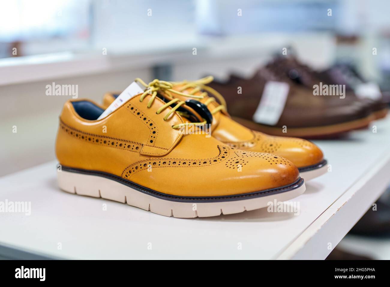 Mustard-colored leather men's boots in a shoe store Stock Photo - Alamy