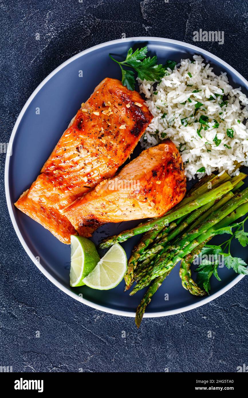 fried salmon fish fillets with asparagus, jasmine rice and lime on a ...