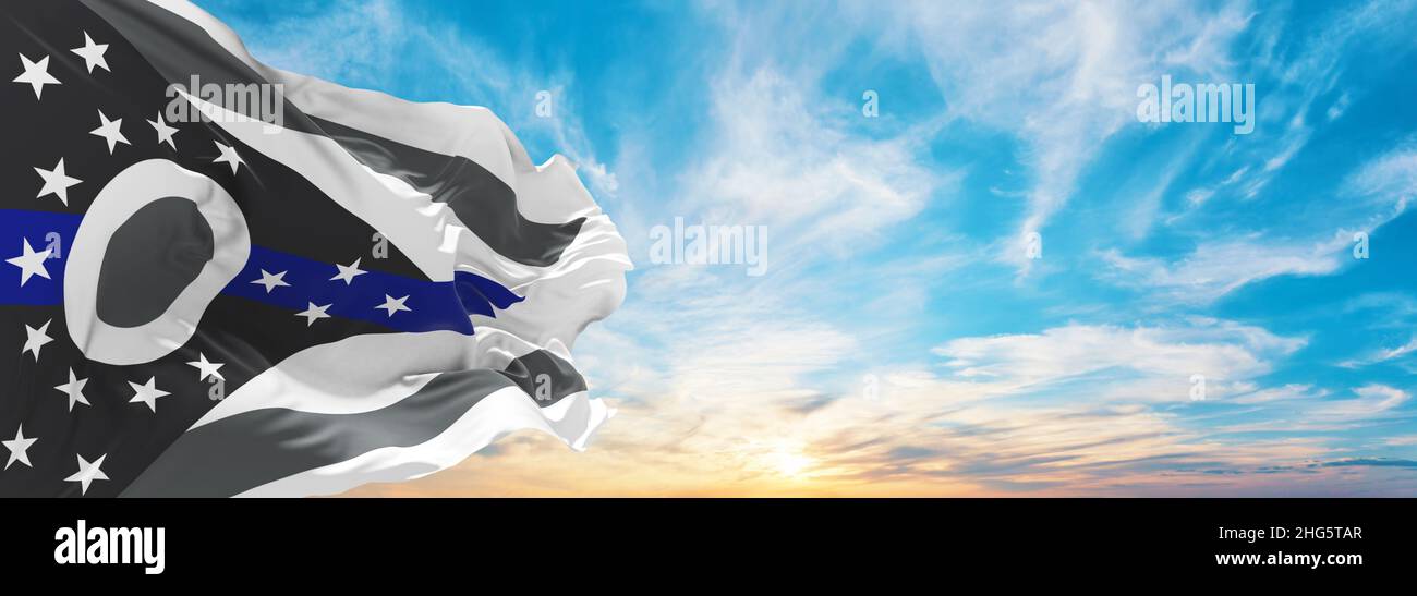 blue line flag of Ohio state, Usa at cloudy sky background on sunset ...