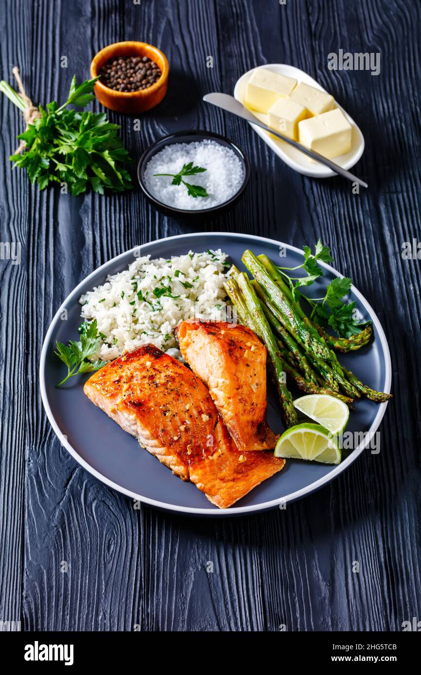 fried salmon fish fillets with asparagus, jasmine rice and lime on a ...