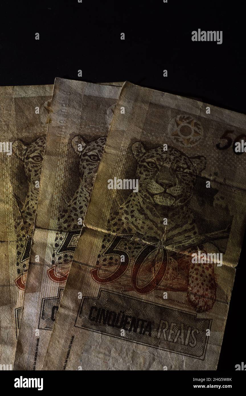 Fifty real note with hand holding, brasilian money, dark background and ...