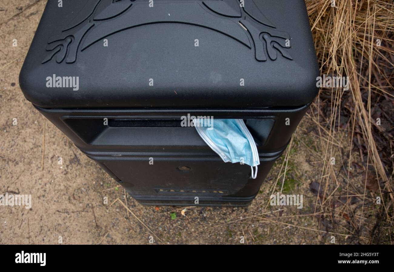 black litter bin with discarded face mask shot from above Stock Photo ...