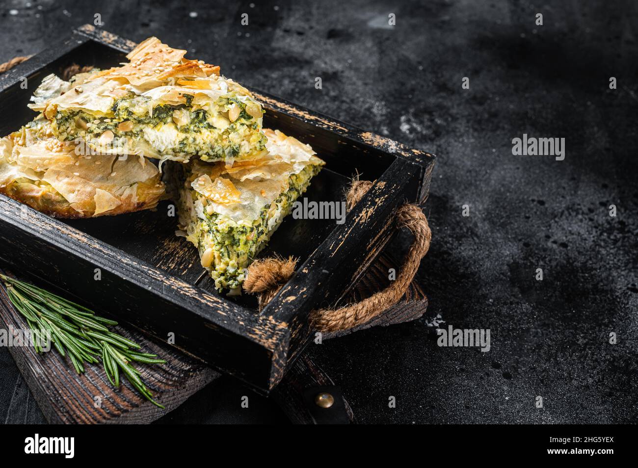 Spinach pie pieces, Spanakopita Greek Pie in wooden tray. Black ...