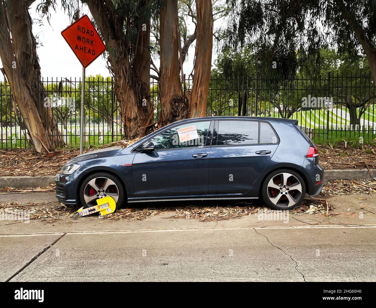 A car with a wheel clamp, wheel boot, or parking boot Stock Photo - Alamy