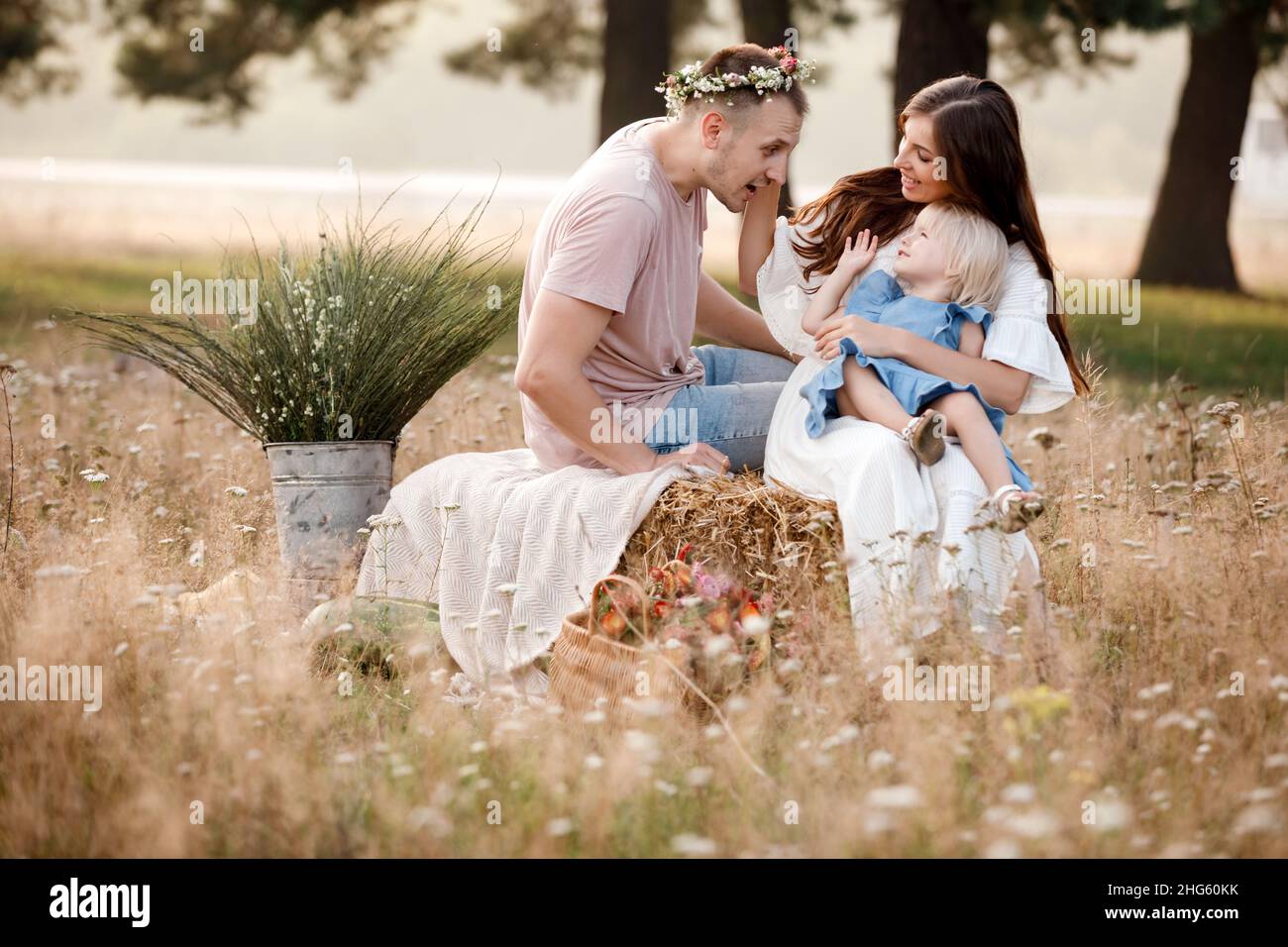Happy family together: beautiful young parents in white clothes hugging ...