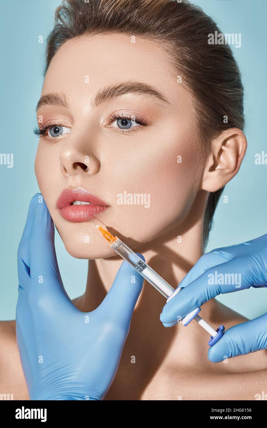 Lip augmentation procedure. Syringe with lips filler near beautiful ...