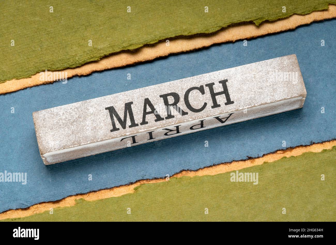 March text on grunge wooden block against handmade rag paper in blue ...