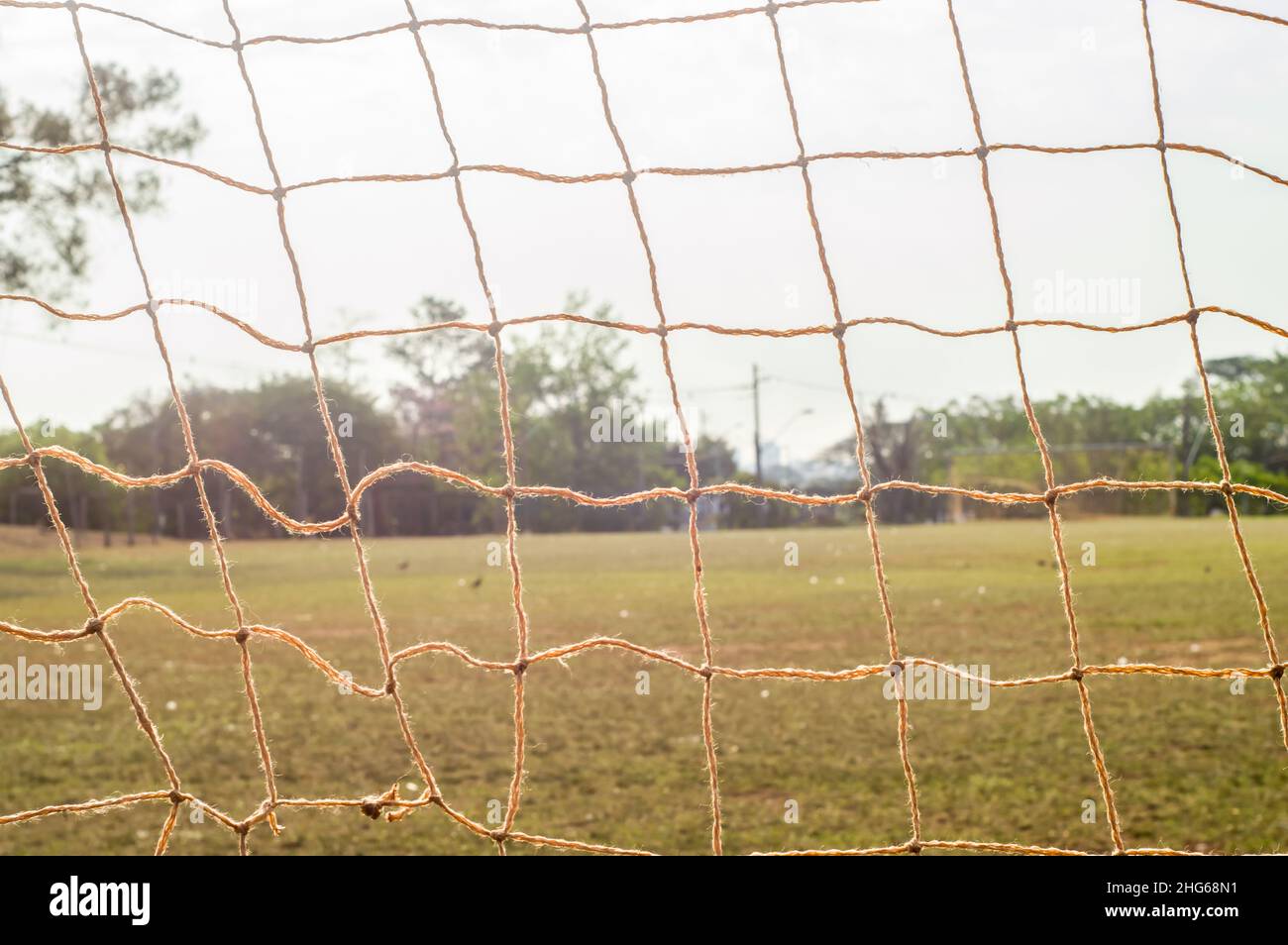 texture with football net, daylight, grass, earth in the background ...