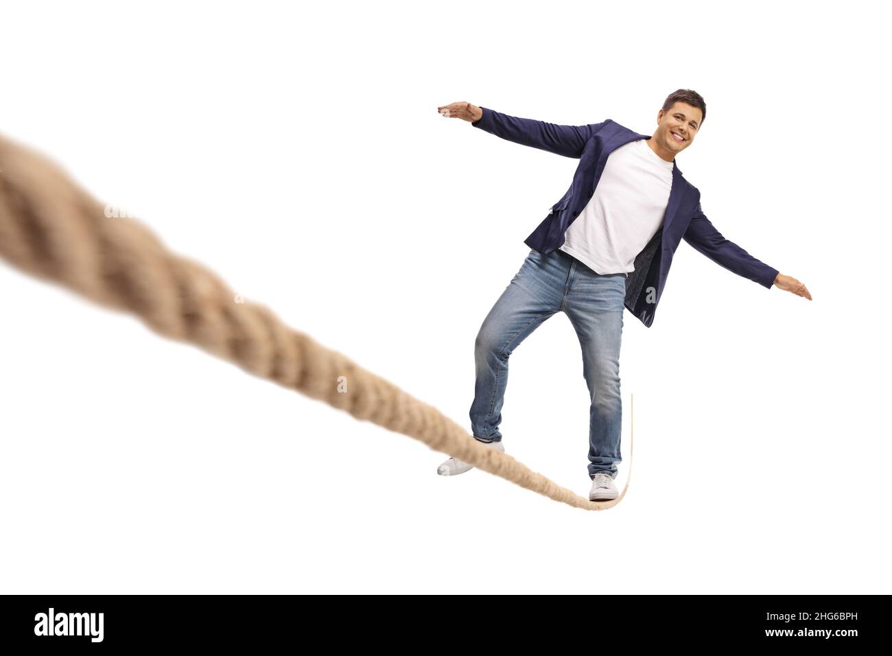 Full length portrait of a smiling young man walking over tightrope ...