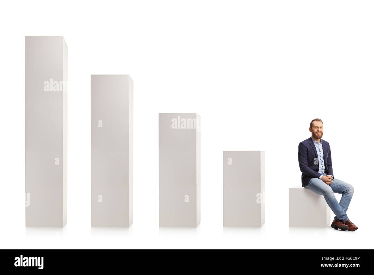 Young professional man in suit and jeans sitting on a column of a chart ...