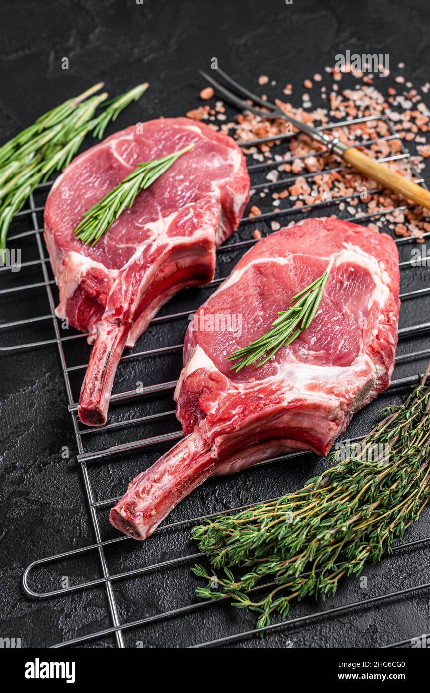 Fresh Raw Tomahawk rib eye beef steaks on grill. Black background. Top ...