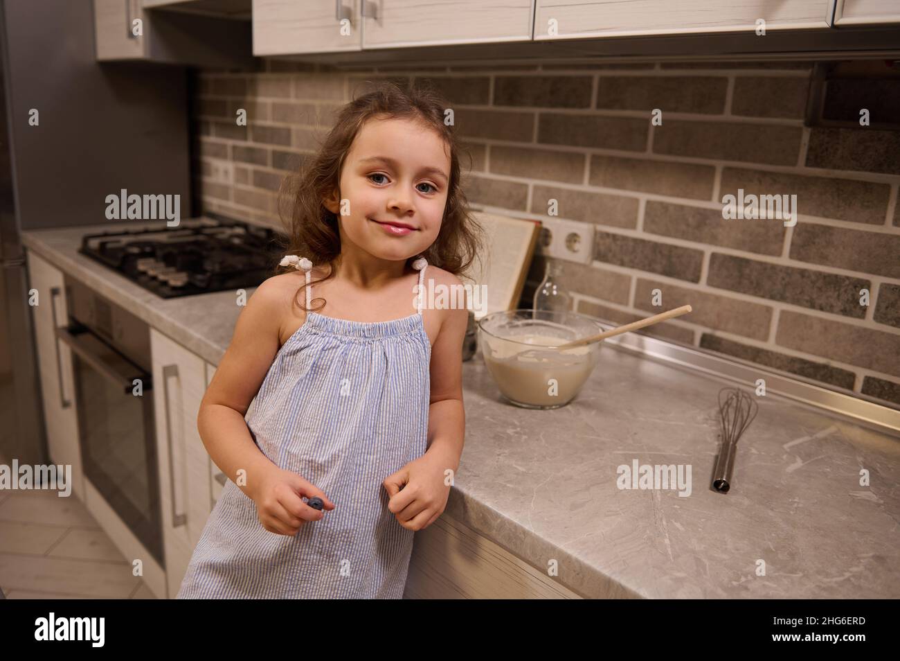 Portrait of a happy adorable beautiful little European girl in blue ...