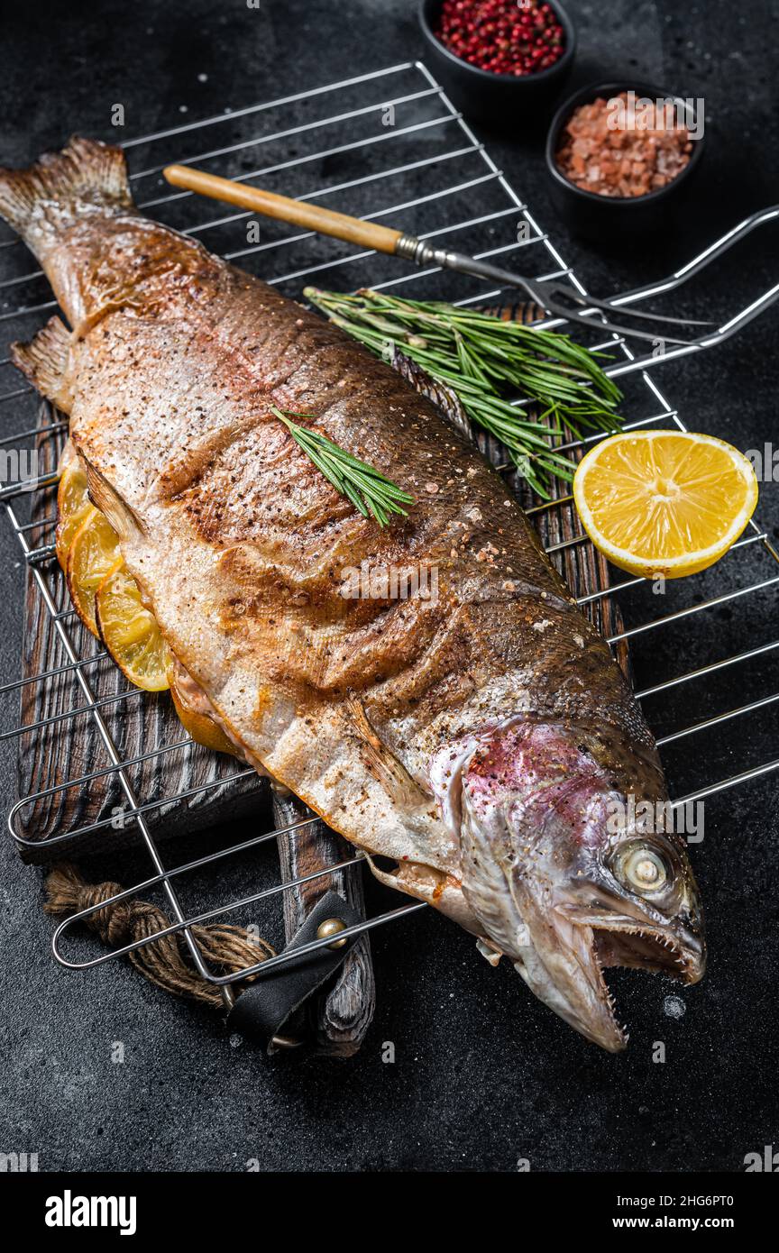 BBQ roasted sea trout, grilled fish on a grill with rosemary. Black ...