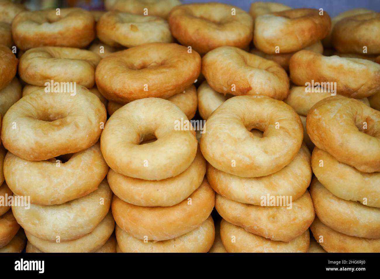 Sugared stacked mini donuts. a pile of sweet Golden-brown doughnuts ...