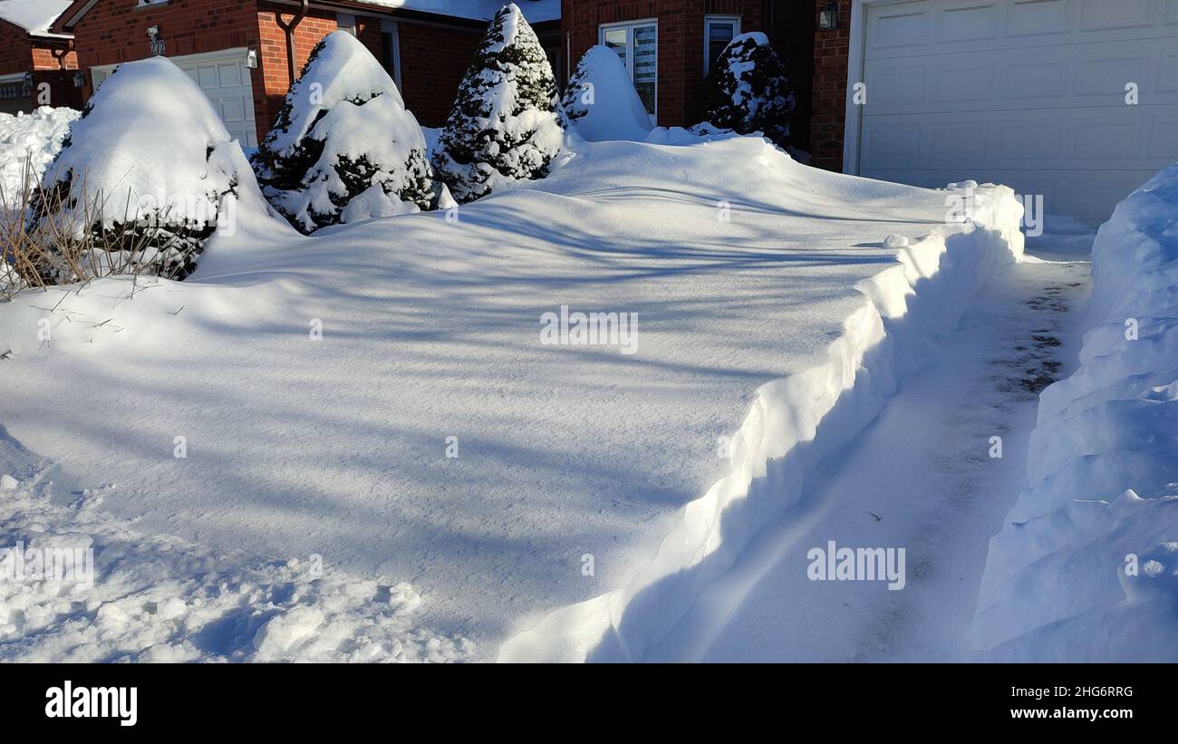 The driveway is covered with deep white snow in Canada for a weather or ...