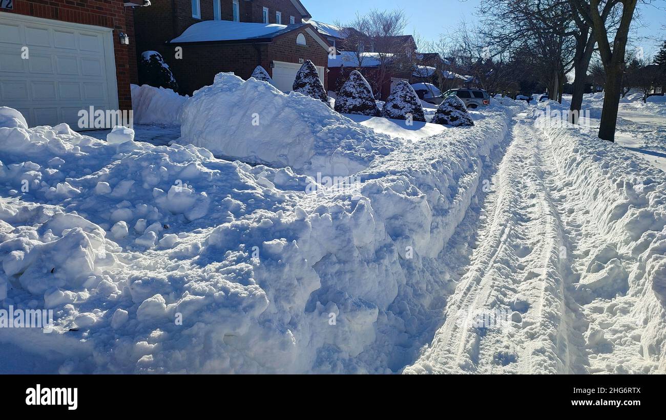 The footpath and driveway are covered with deep white snow in Canada ...