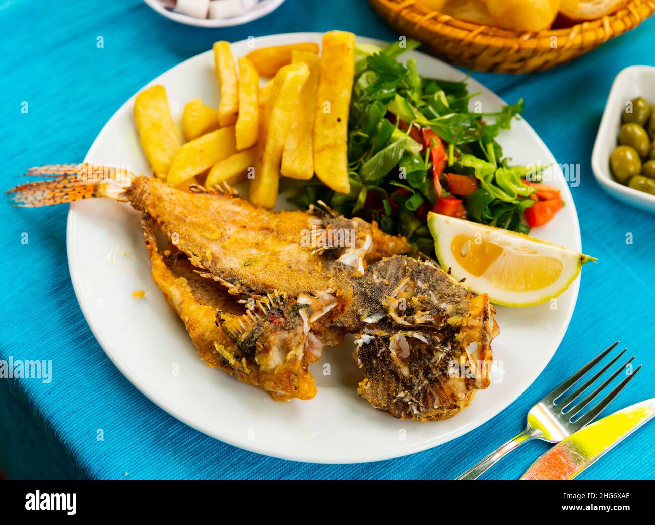 Roasted lionfish with potatoes and fresh greens Stock Photo - Alamy