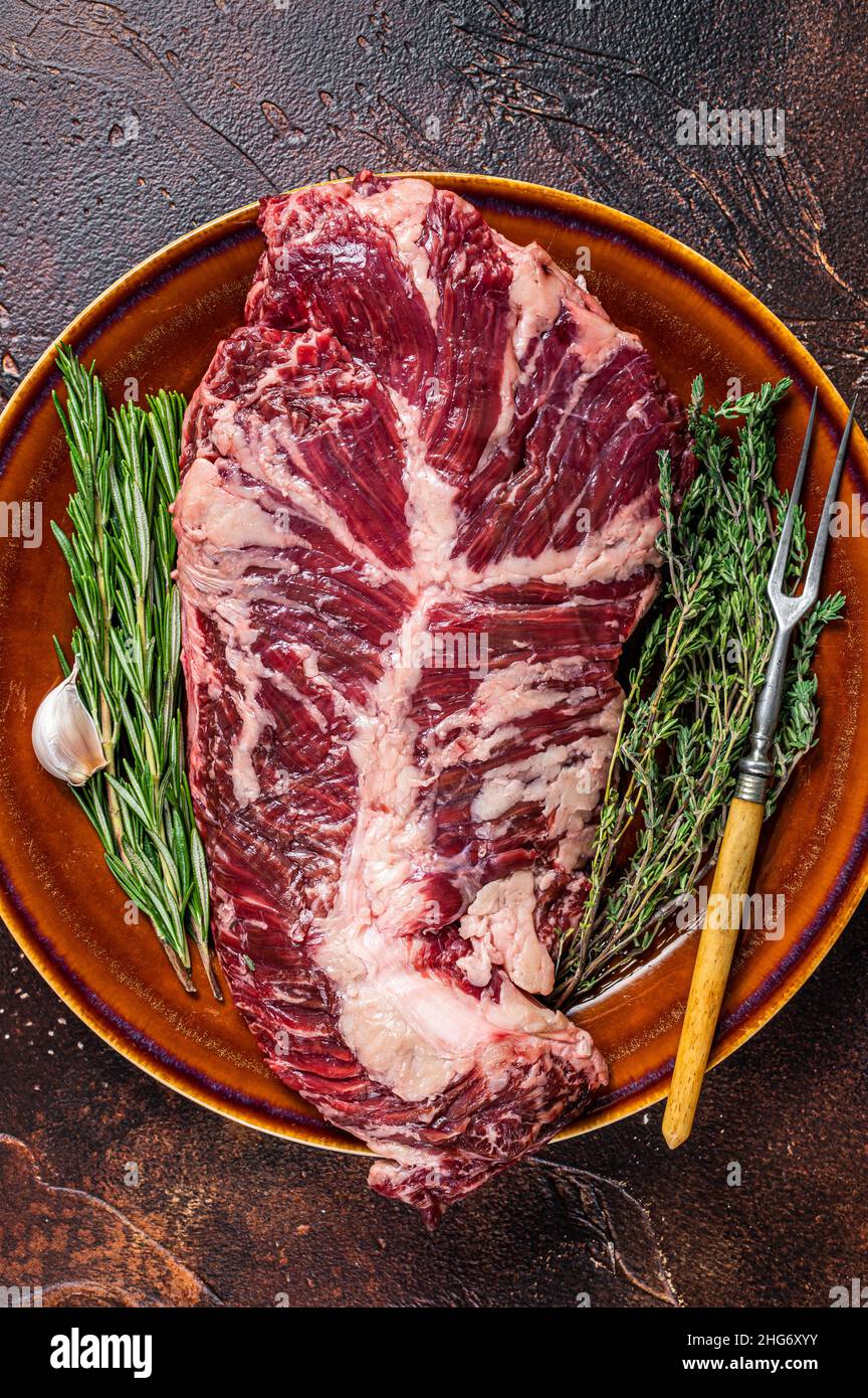 Raw hanging tender or ongle beef meat steak on rustic plate with herbs ...