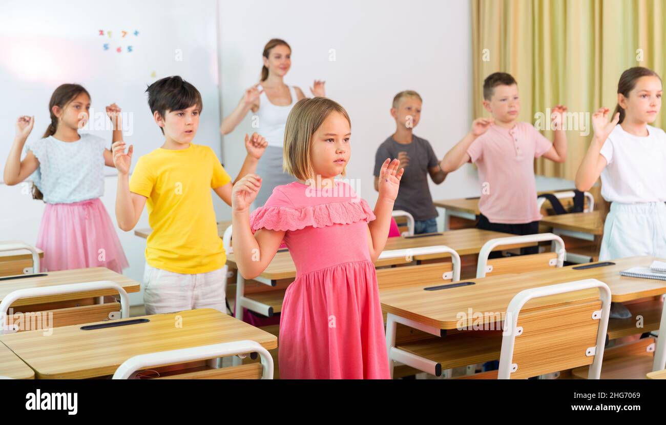 Small school kids doing physical exercises with teacher Stock Photo - Alamy
