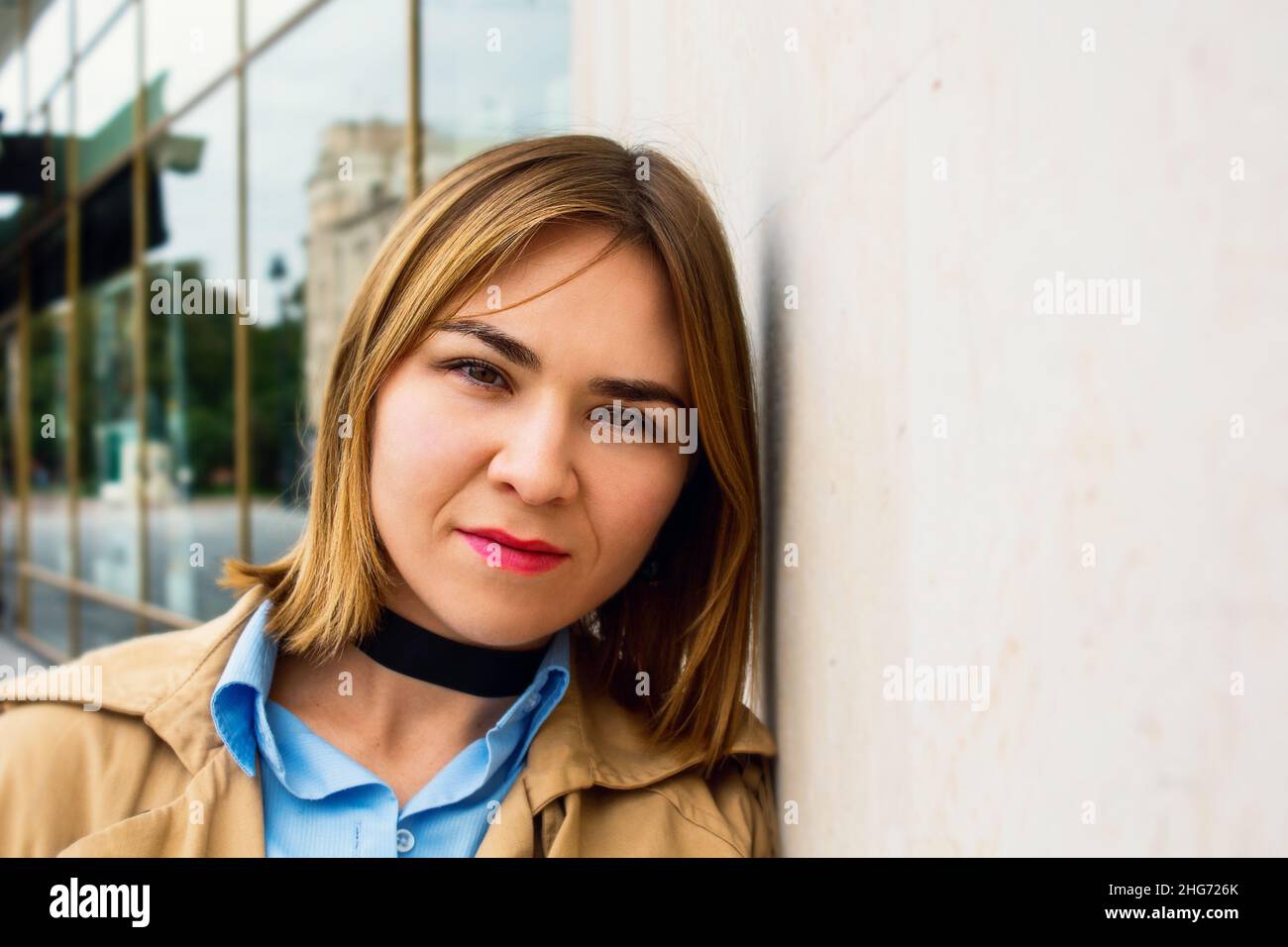 Beautiful young woman leaning against the wall Stock Photo - Alamy