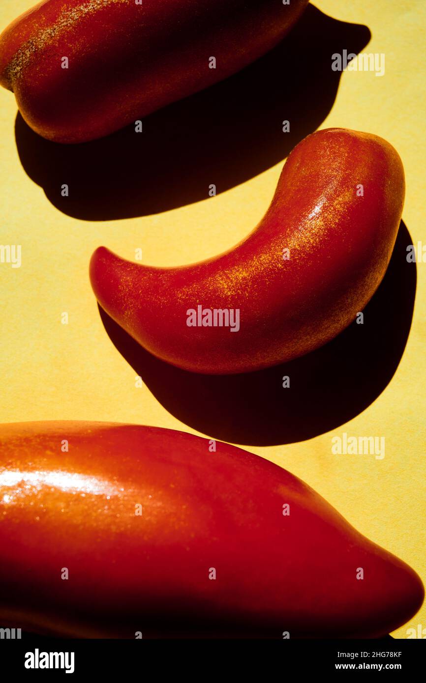 Still life photograph of red San Marzano tomatoes on a yellow ...