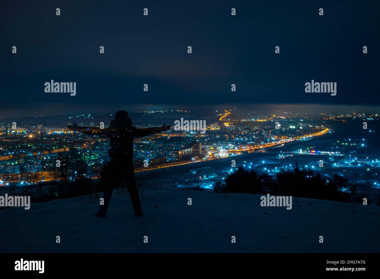 fuzzy blurred night silhouette of a man who on the mountain spread his ...