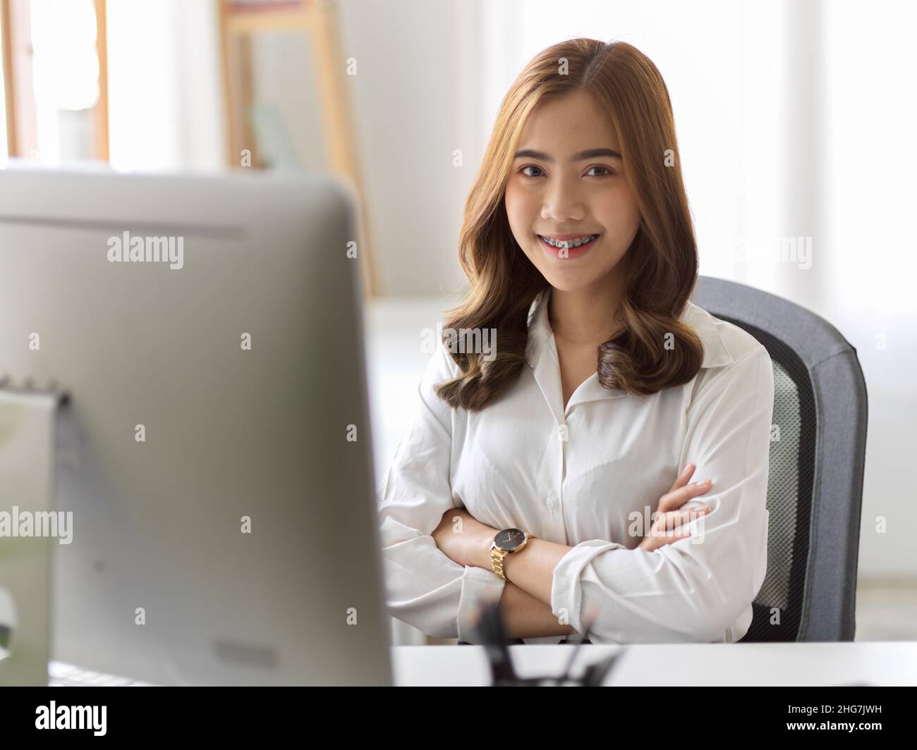 Beautiful young Asian female worker or employee sitting at her ...