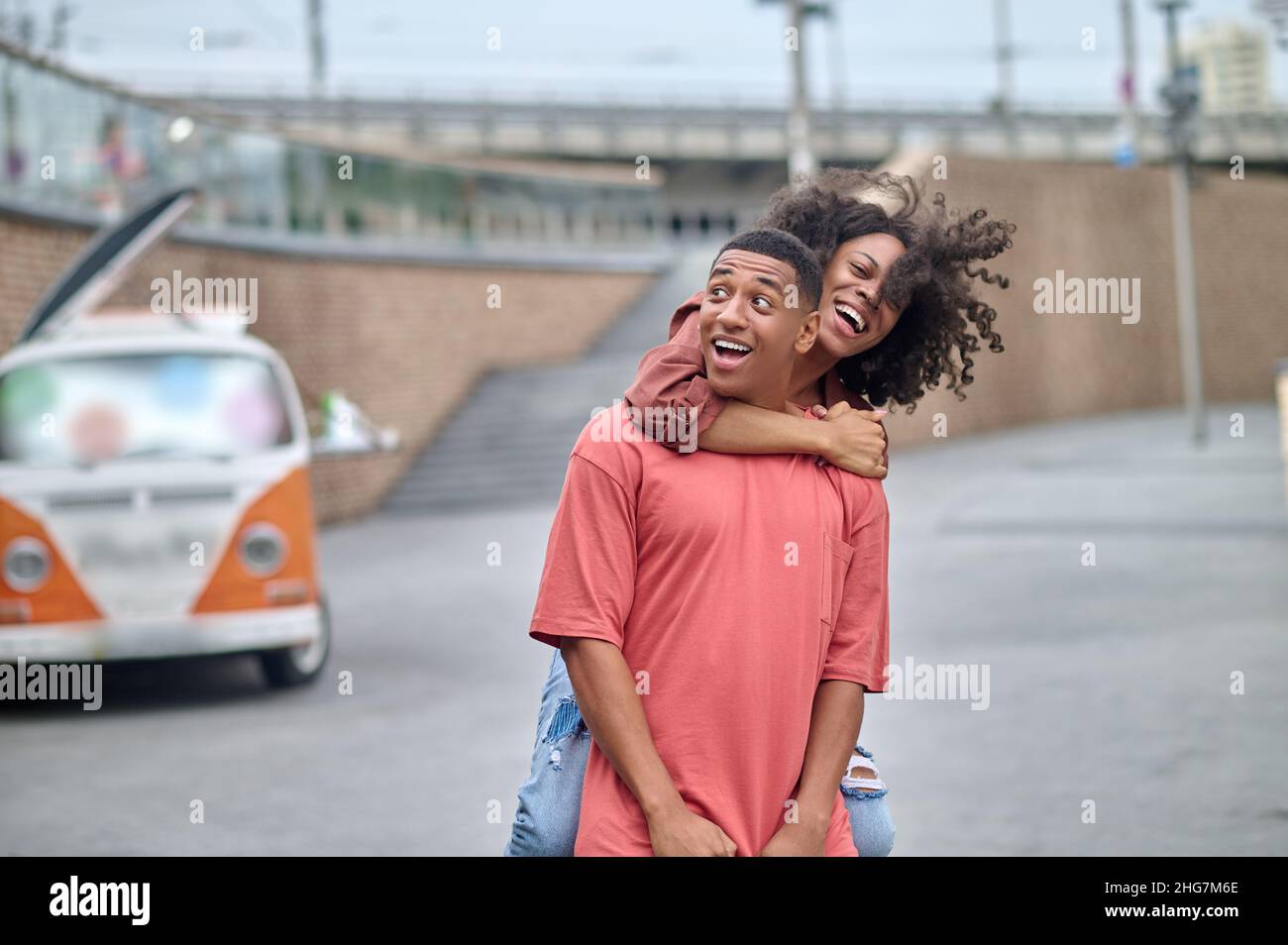 Laughing woman on back of surprised man Stock Photo - Alamy
