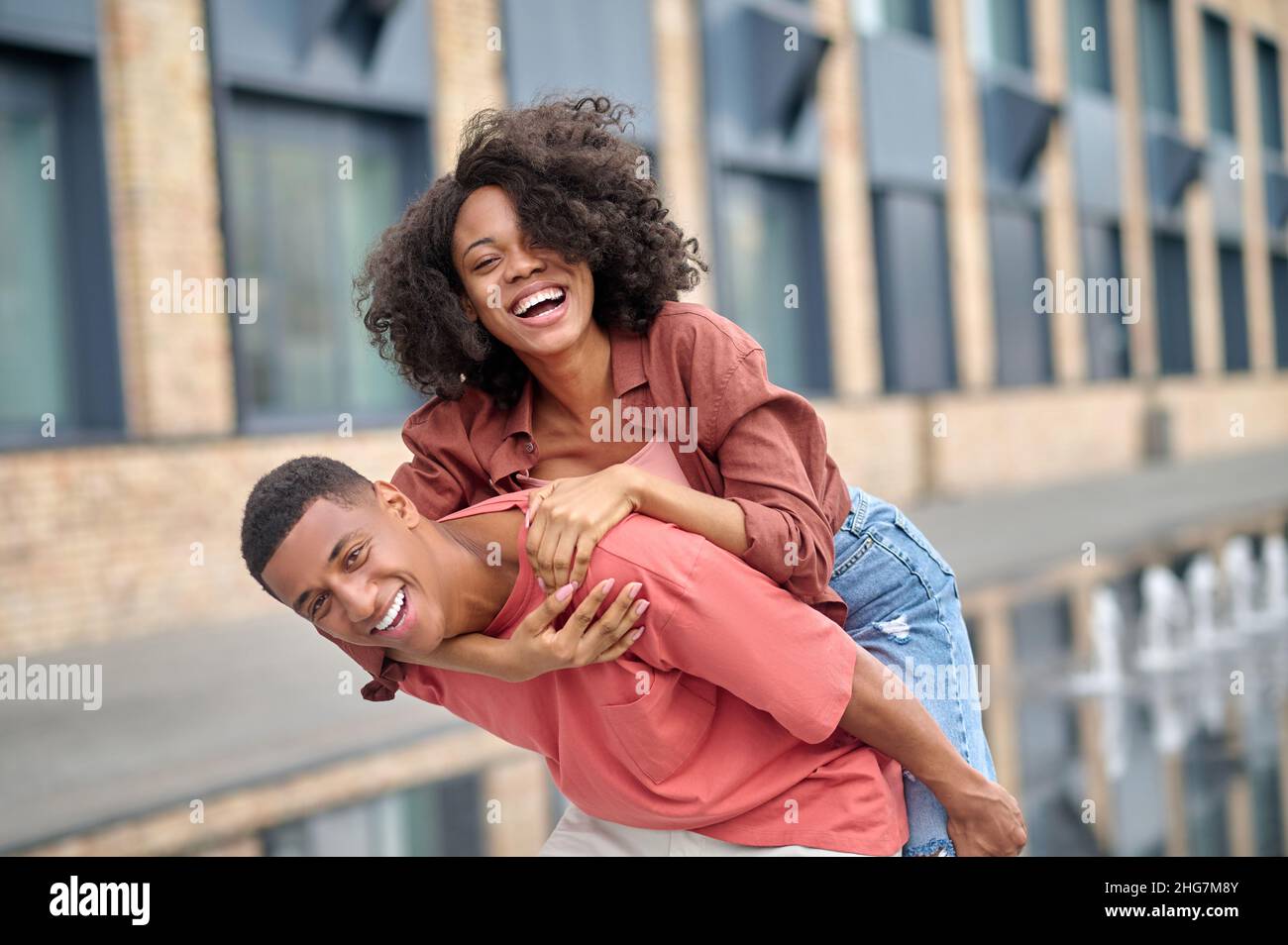 Man carrying woman on back looking at camera Stock Photo - Alamy