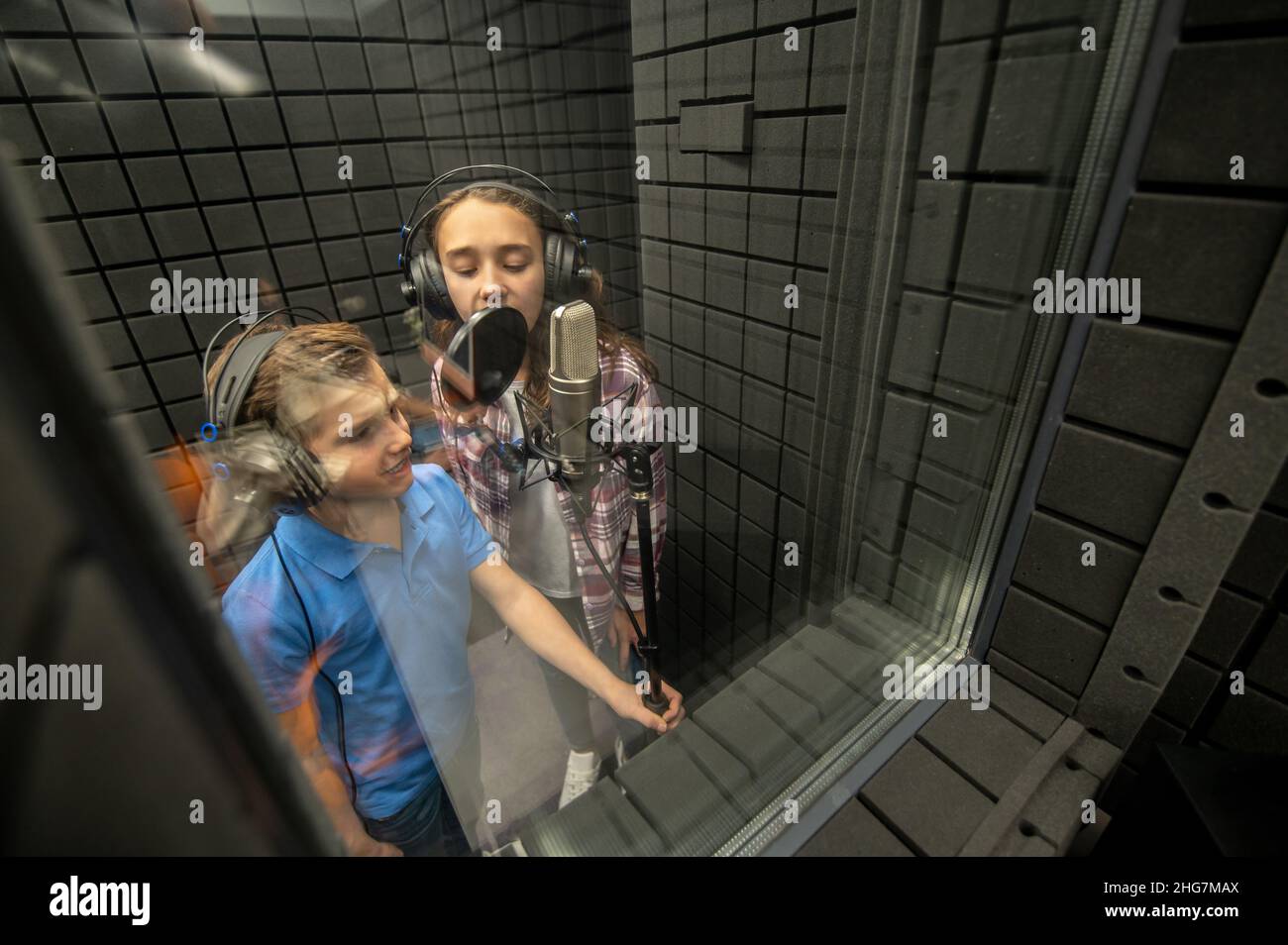 Young singers singing into the mike in the recording studio Stock Photo ...