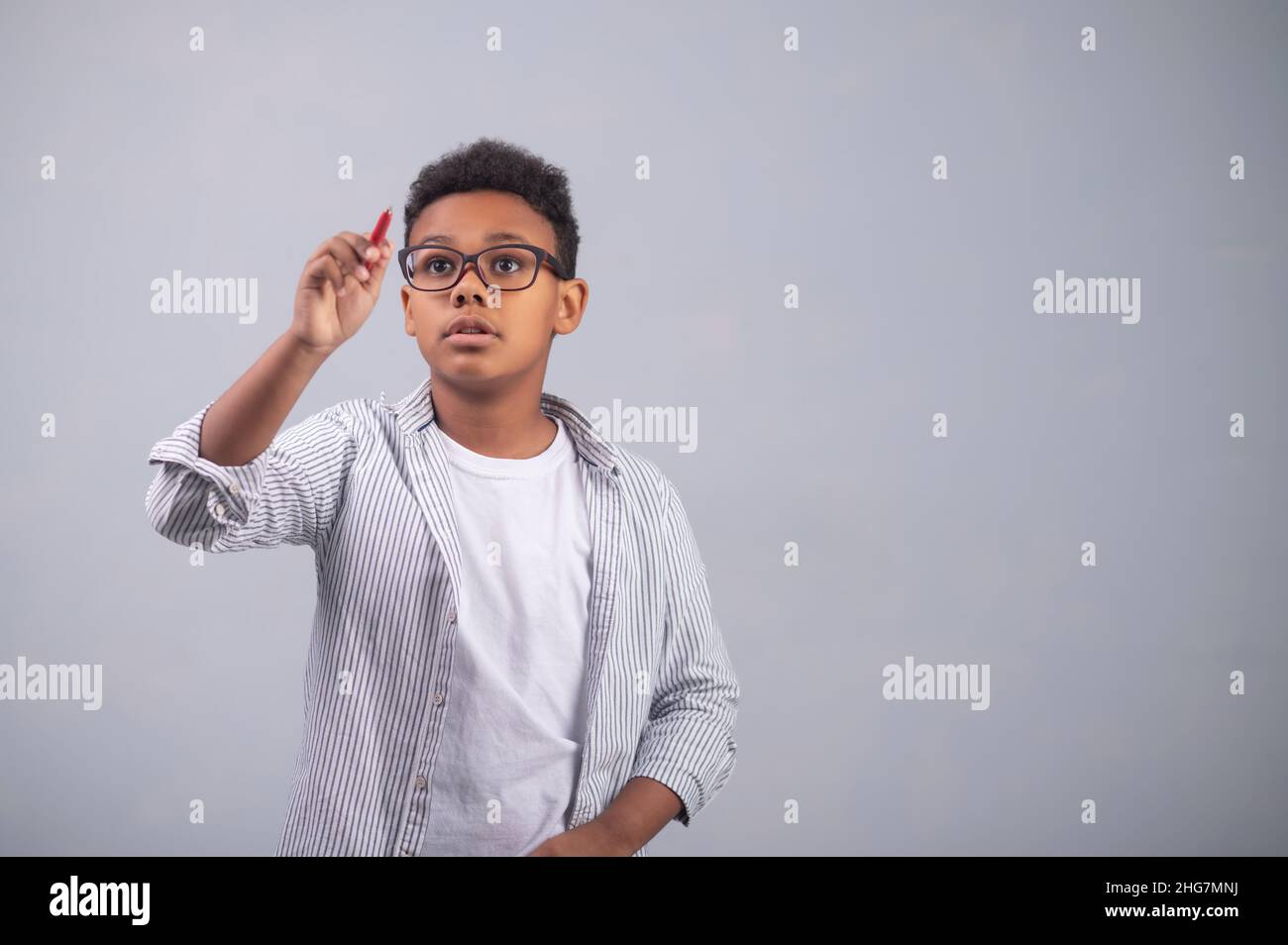 Serious concentrated kid drawing with a pencil Stock Photo - Alamy