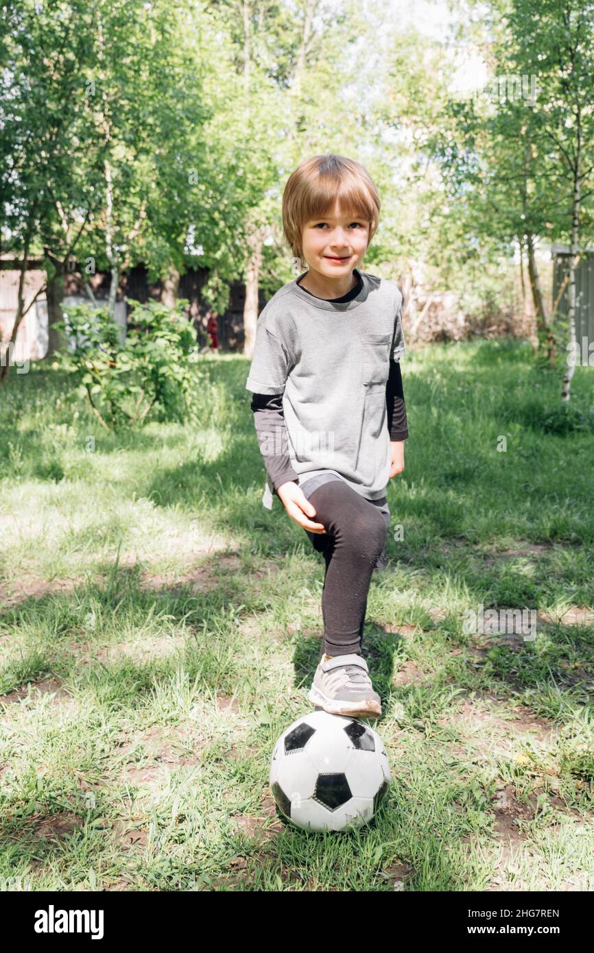 Kid playing football in the yard Stock Photo - Alamy