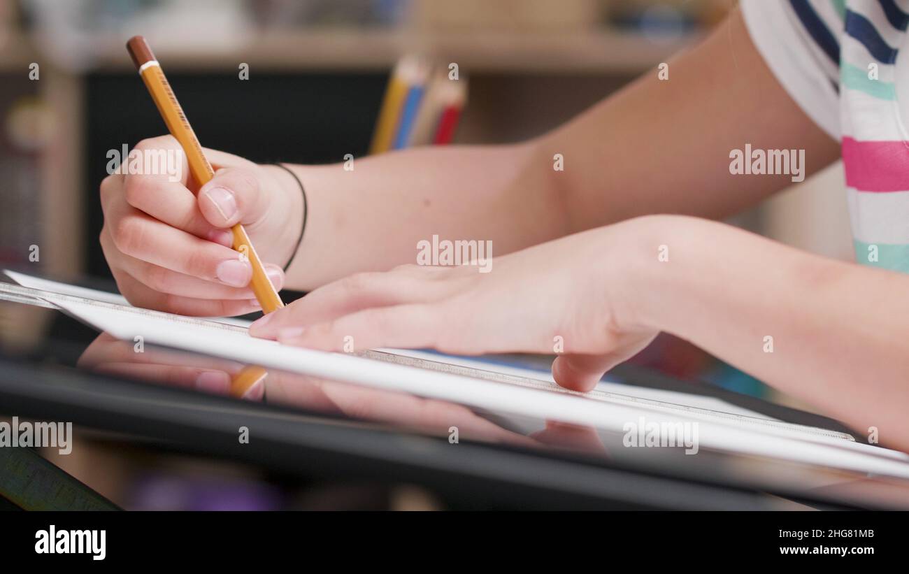 Closeup of young child artist hand drawing on paper using graphic ...