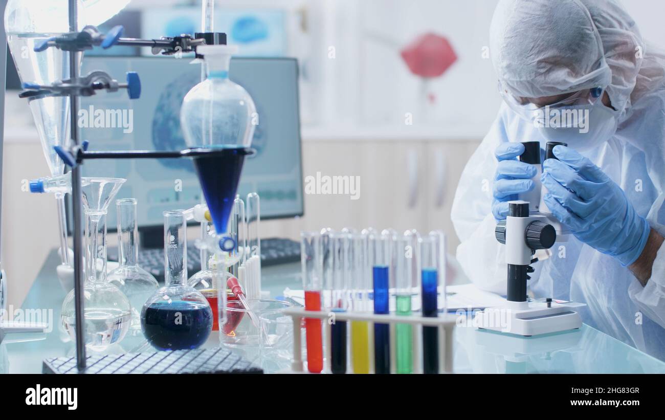 Microbiologist researcher with ppe equipment analyzing virus sample ...