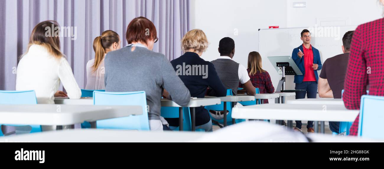 Students working with professor in auditorium Stock Photo - Alamy