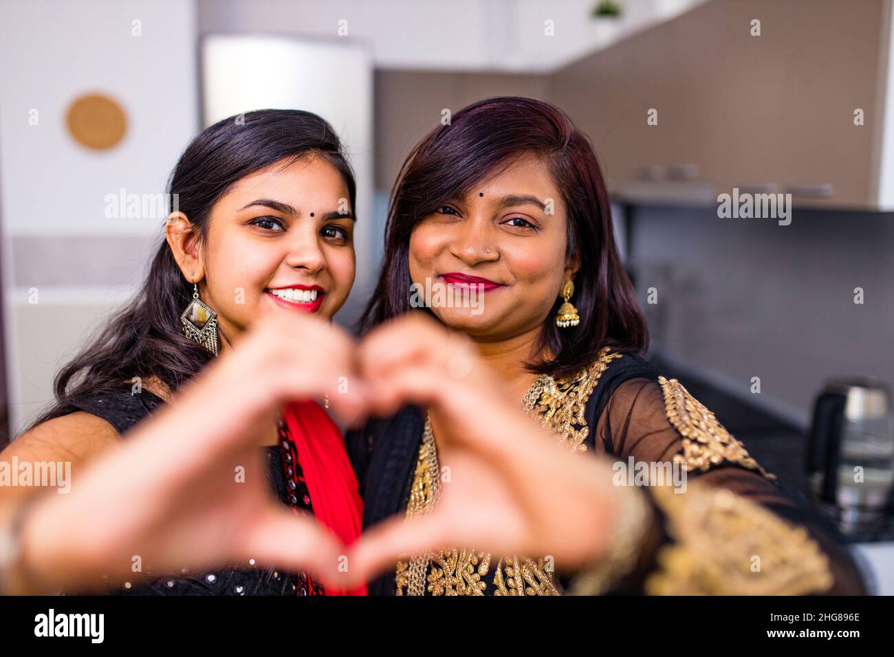 happy mixed race friends emracing hugging greeting each other in living ...